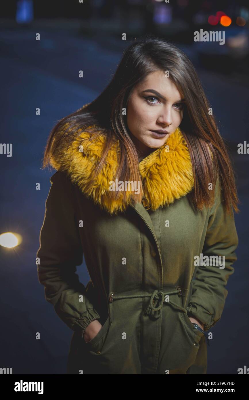 Pretty young Bosnian lady wearing a fur collar jacket is posing ...