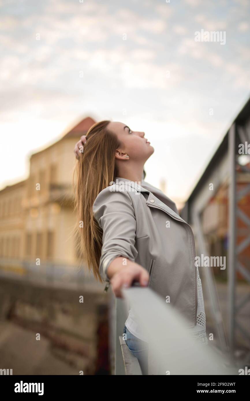 Young Bosnian girl leaning with her back against the railing while ...
