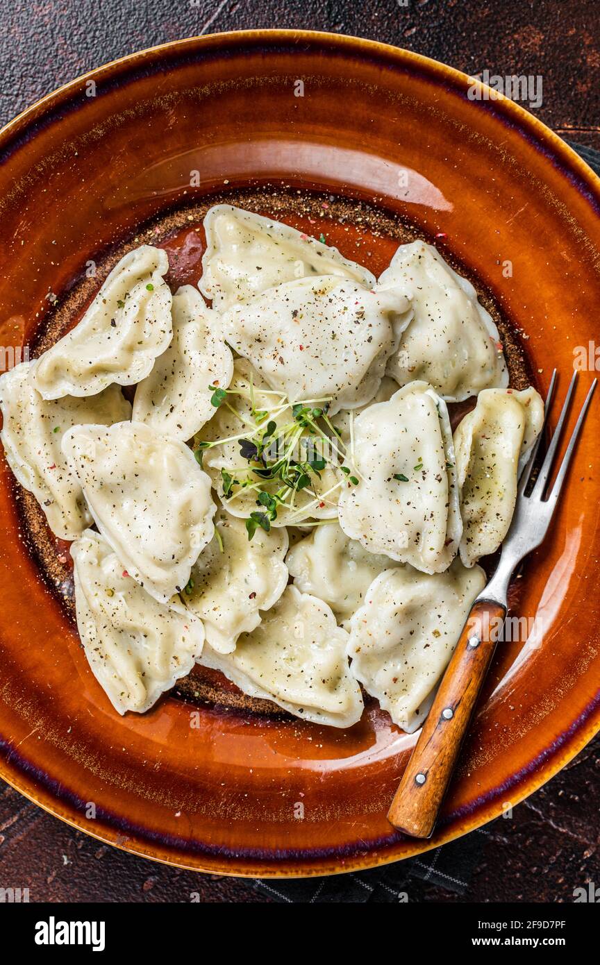 Polish Pierogi Dumplings with potato in a plate with herbs and butter ...