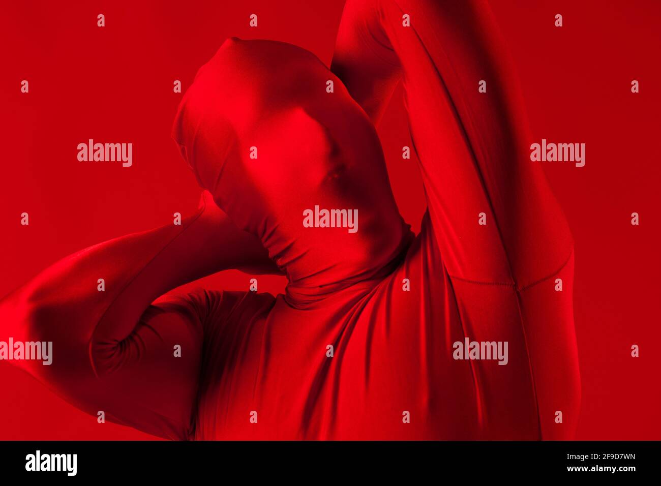 A screaming man in a red full suit, on a red background. The concept of ...