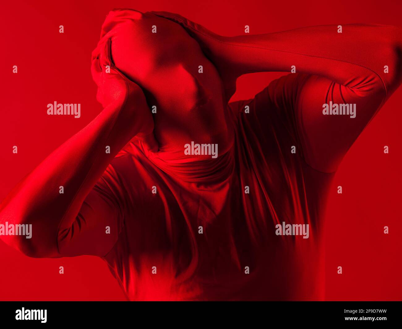 A screaming man in a red full suit, on a red background. The concept of ...