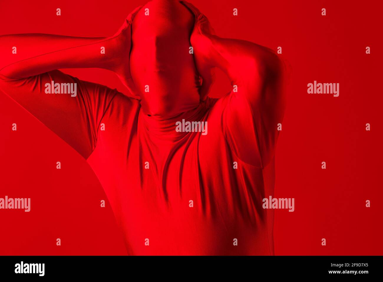 A screaming man in a red full suit, on a red background. The concept of ...