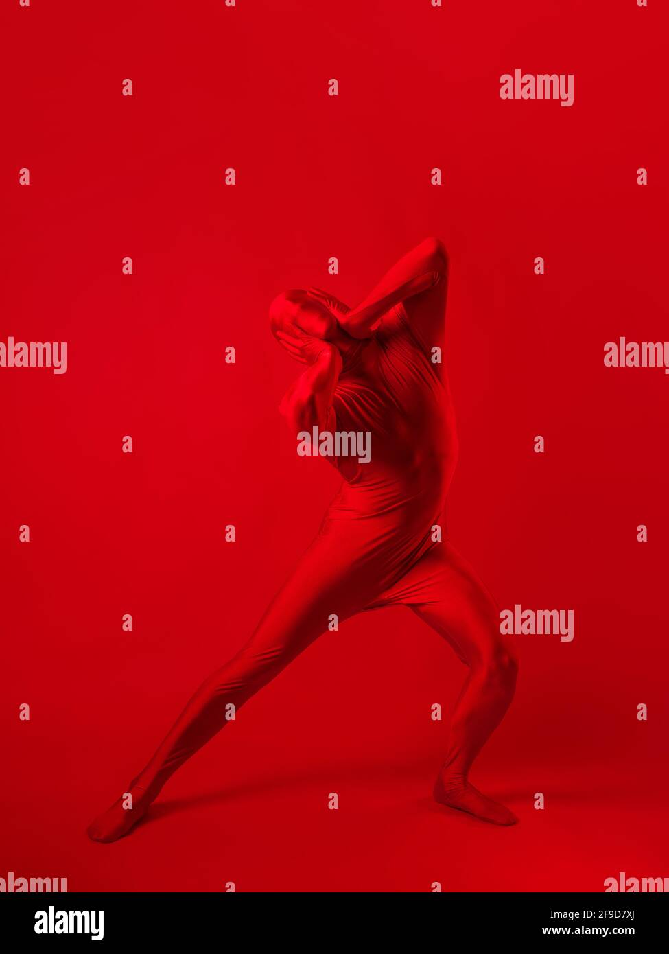 A screaming man in a red full suit, on a red background. The concept of ...