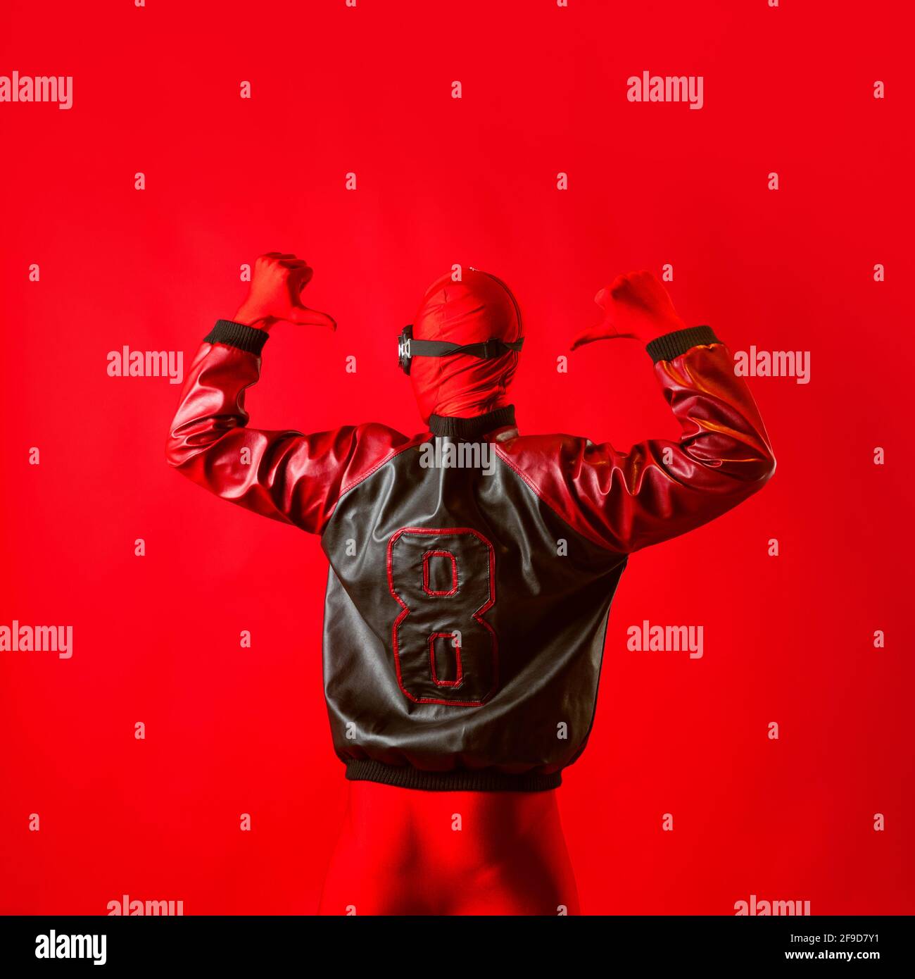 A funny super hero in a red leotard and protective glasses. The man in ...