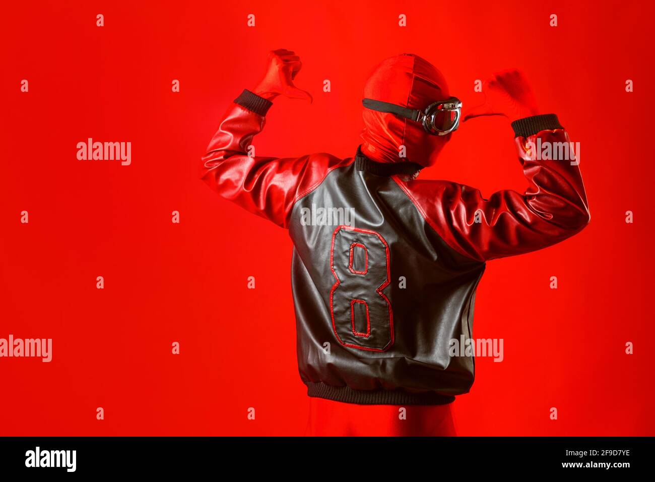 A funny super hero in a red leotard and protective glasses. The man in ...