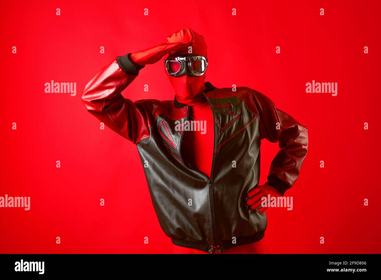 A funny super hero in a red leotard and protective glasses looks ahead ...