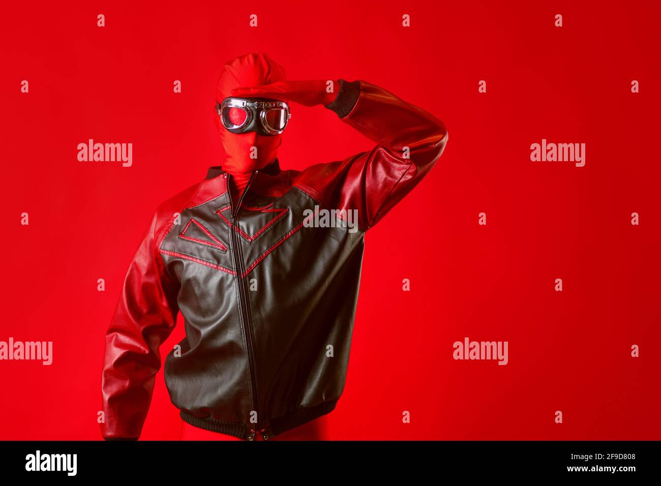 A funny super hero in a red leotard and protective glasses looks ahead ...