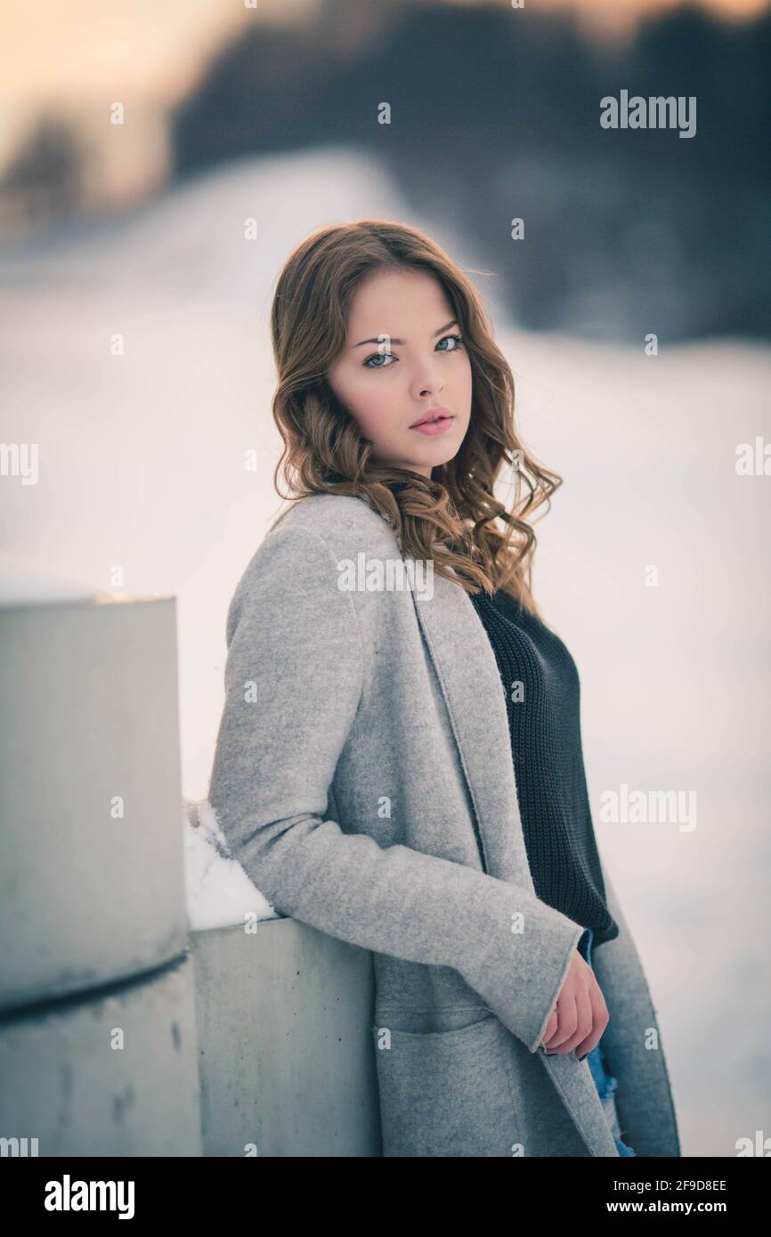 Fierce-looking beautiful Bosnian Caucasian woman in a gray coat in a ...