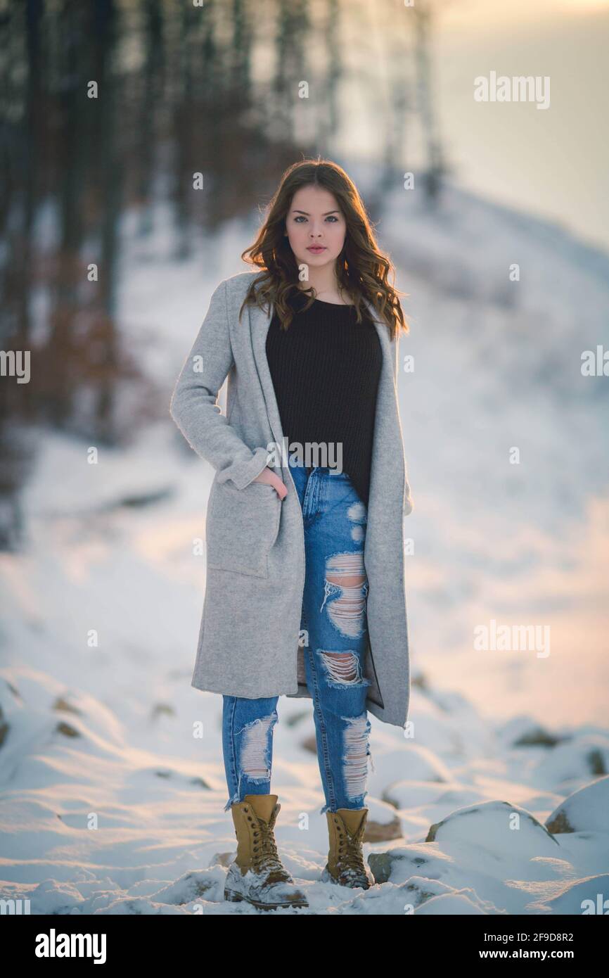 Beautiful Bosnian Caucasian woman in coat and boots looking at the ...