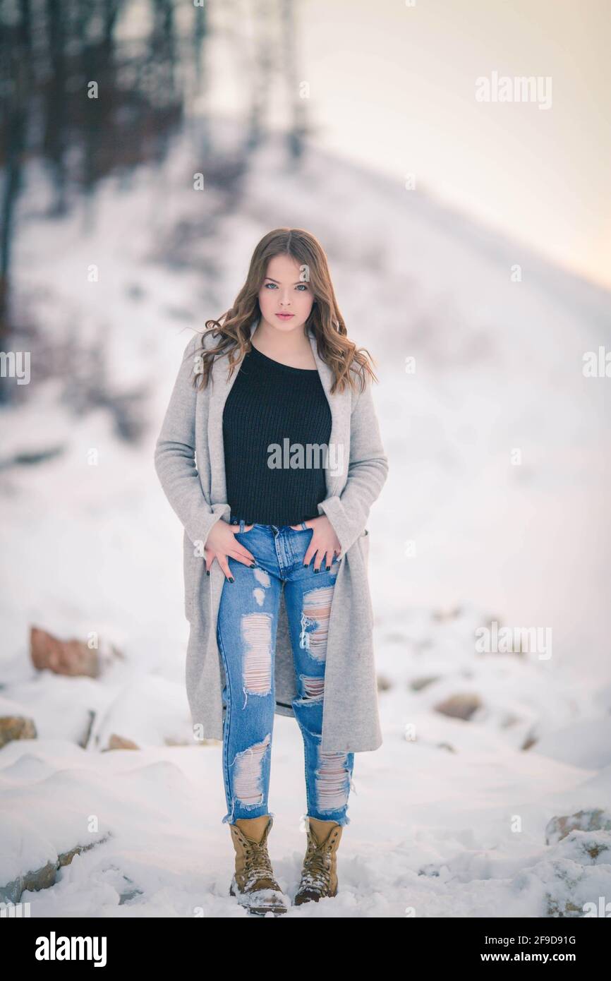 Beautiful Bosnian Caucasian woman in coat and boots looking at the ...