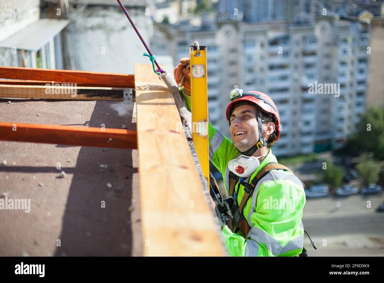 Cheerful industrial climber measuring with level tube during ...