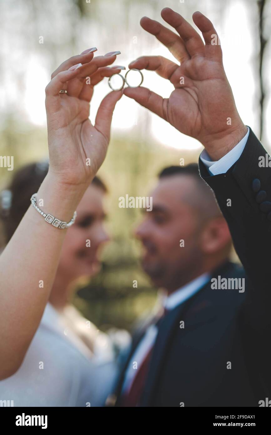 Shallow focus shot of newlyweds hands showing their wedding rings while ...