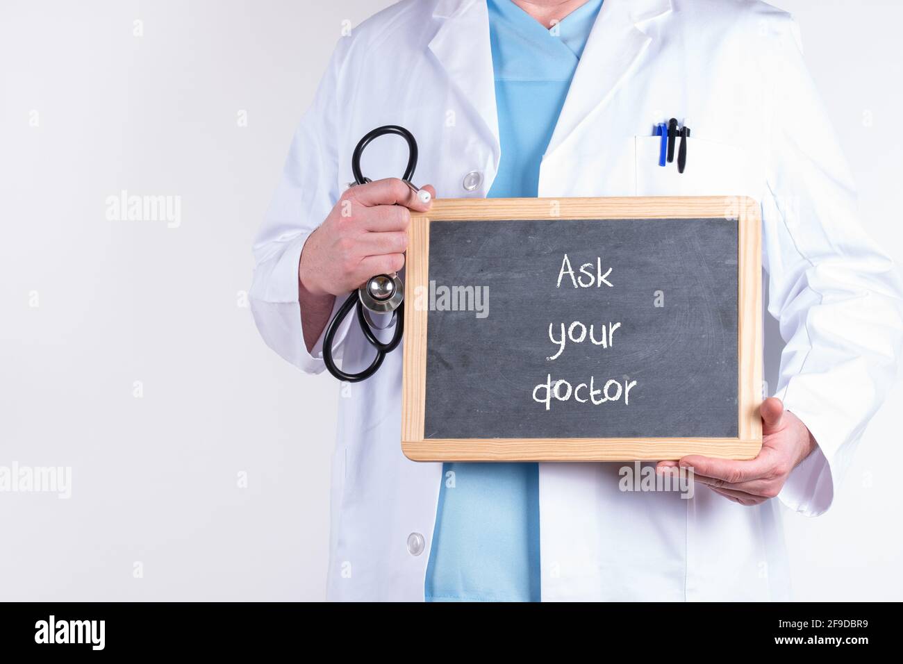 Closeup of a male doctor holding stethoscope and board with a message ...