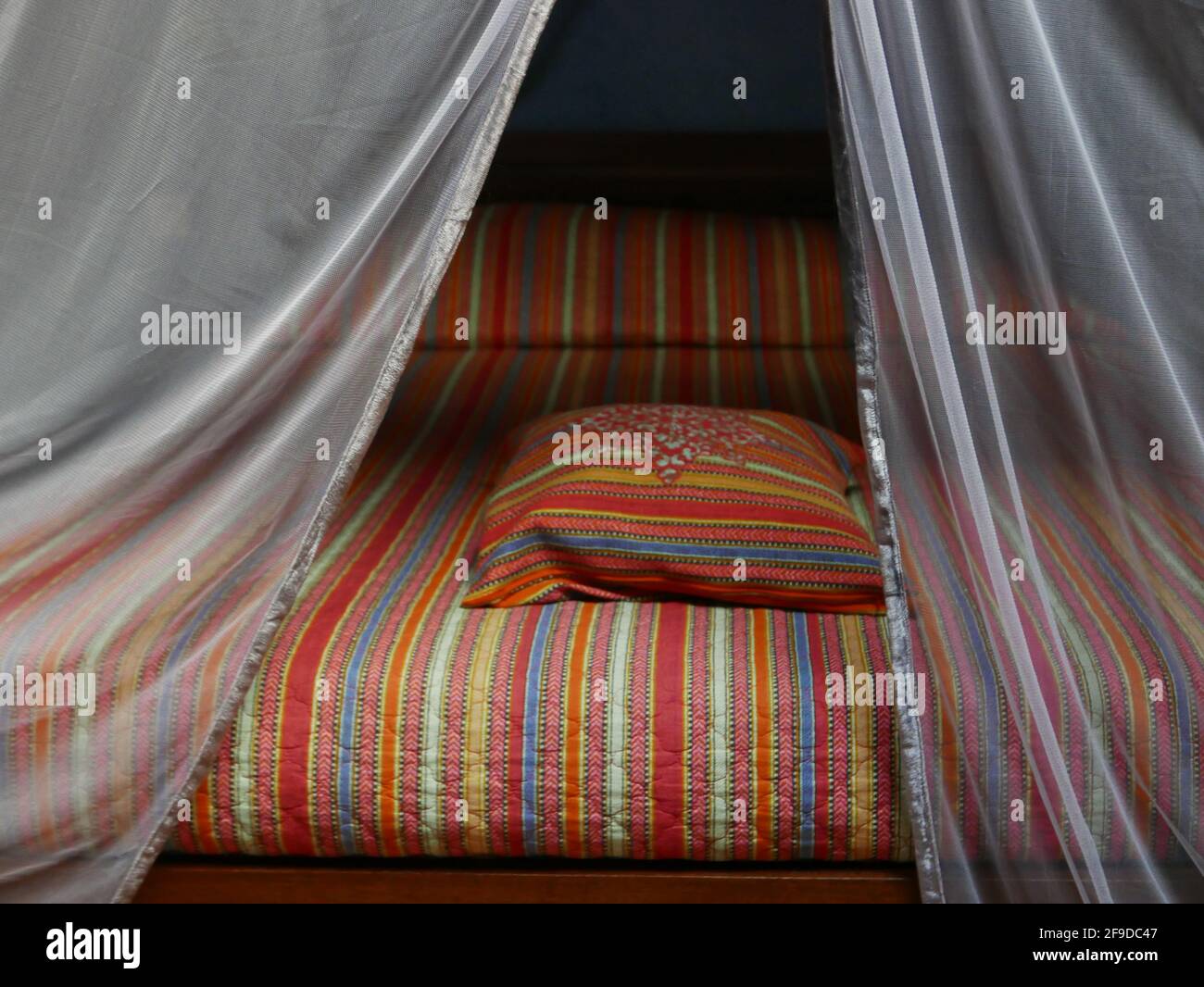 Old fashioned bed behind curtains Stock Photo - Alamy