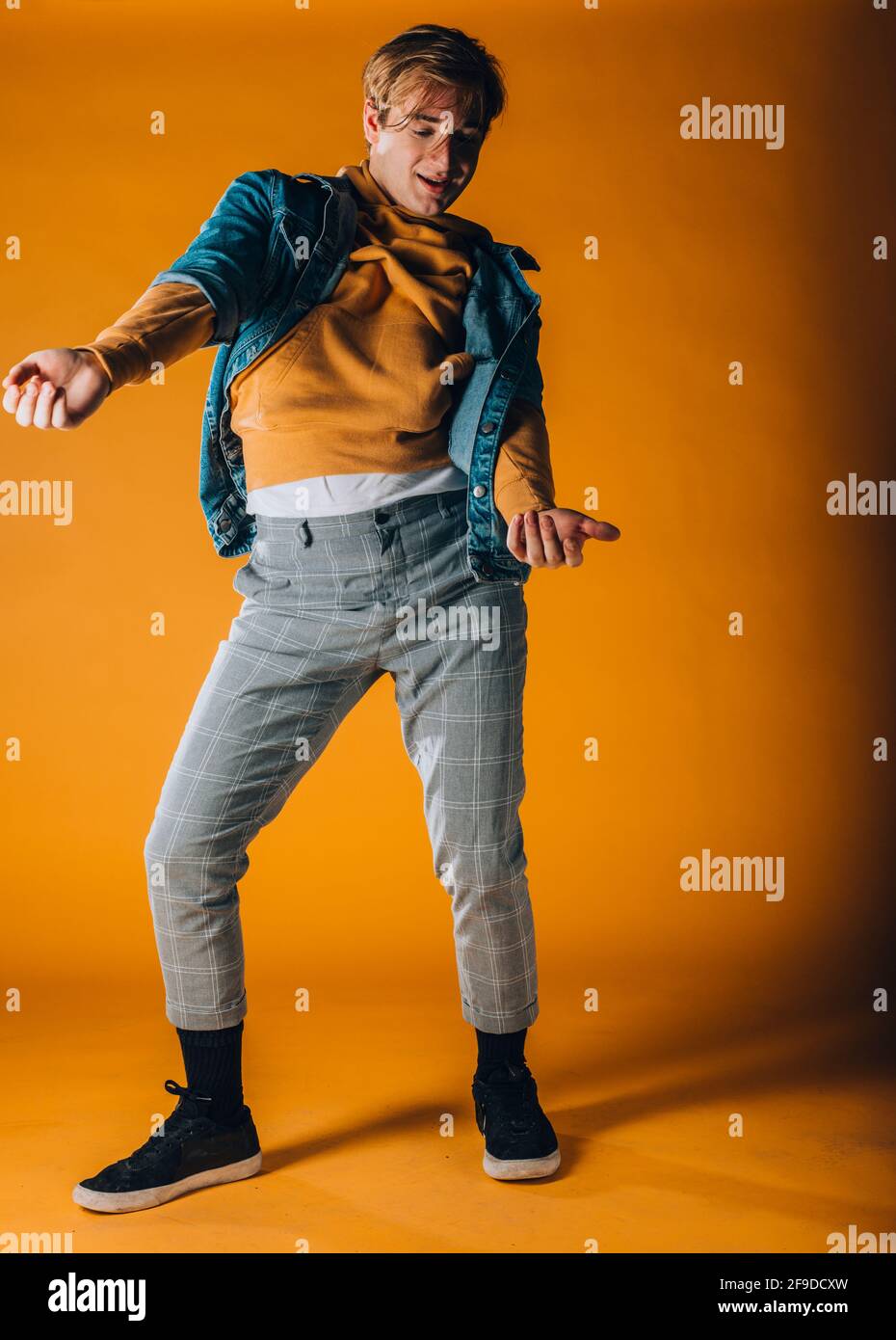 Muscular male dancer performing a dance routine in the orange studio ...