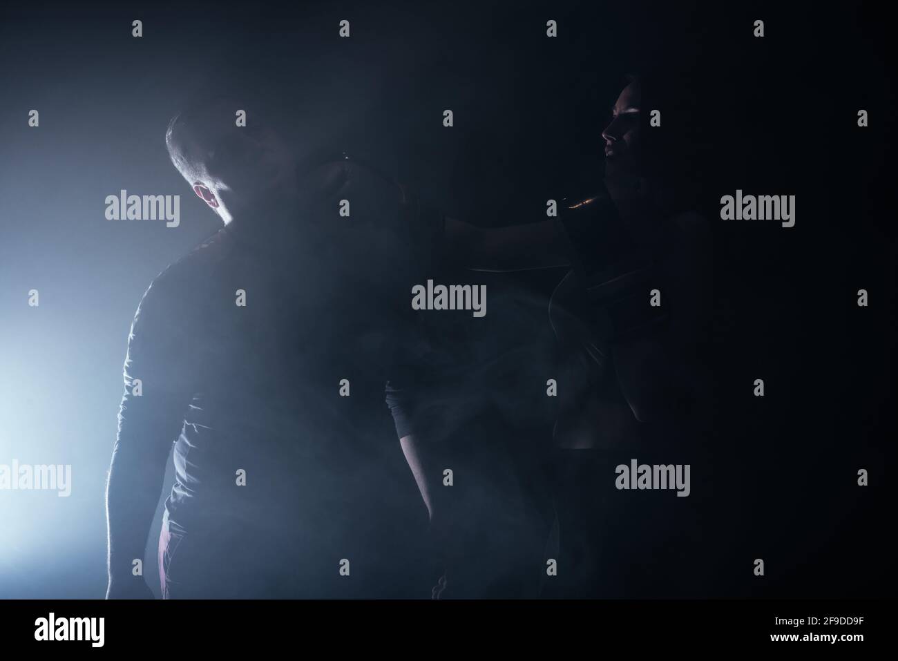 Dark smoky backgound photo of a professional female boxer punching her ...