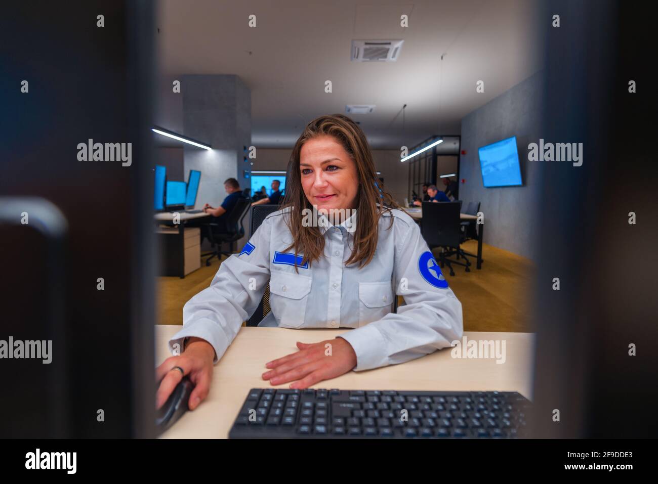 Female security operator working in a security data control room ...