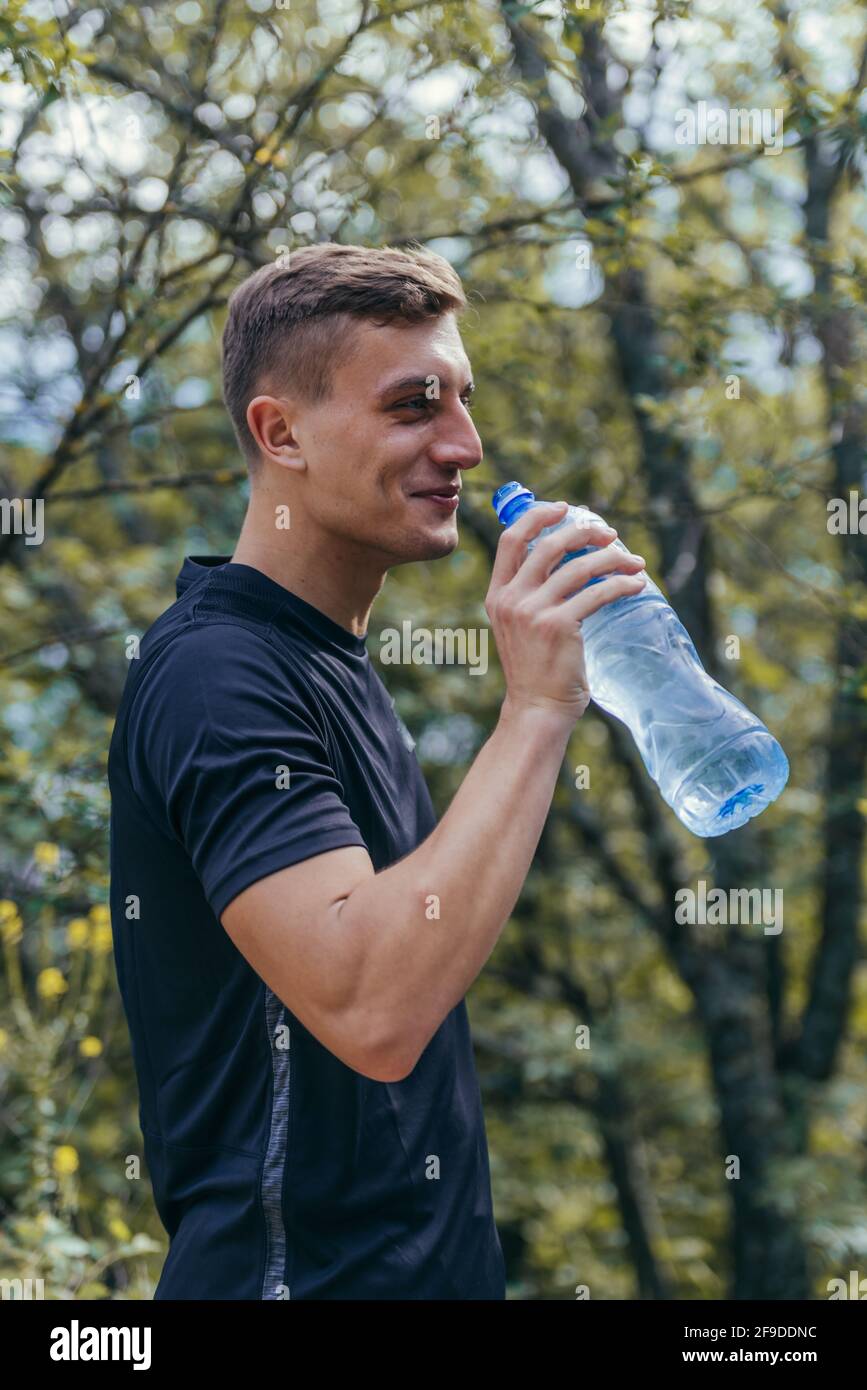 Male athlete drinking water, refreshing, hydrating after a long ...