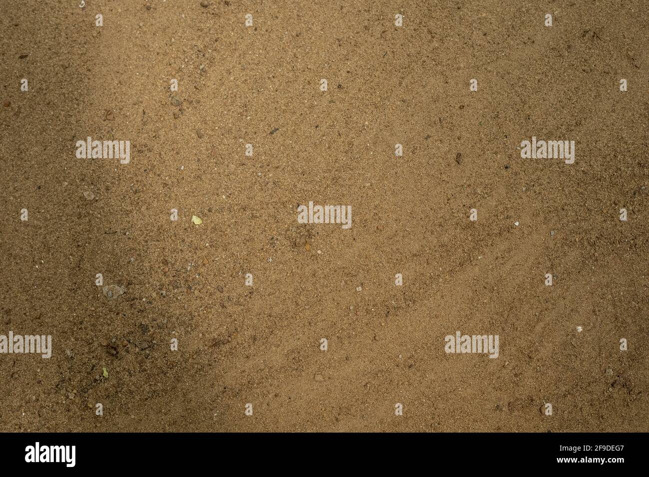 A top view of grainy brown ground with pebbles and rocks - nature ...