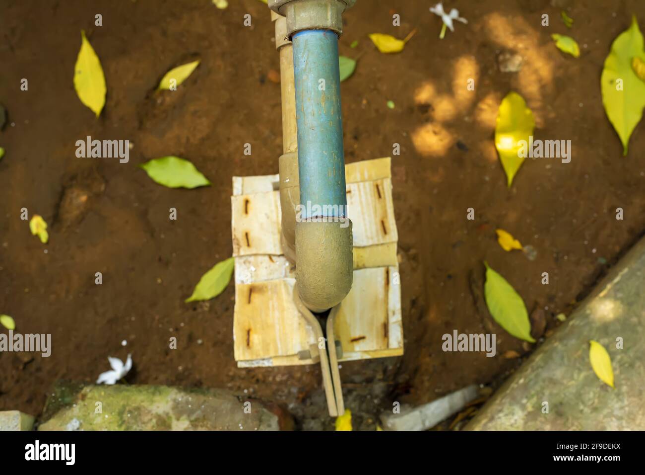 A top view of painted water pipes going through the ground with fallen ...
