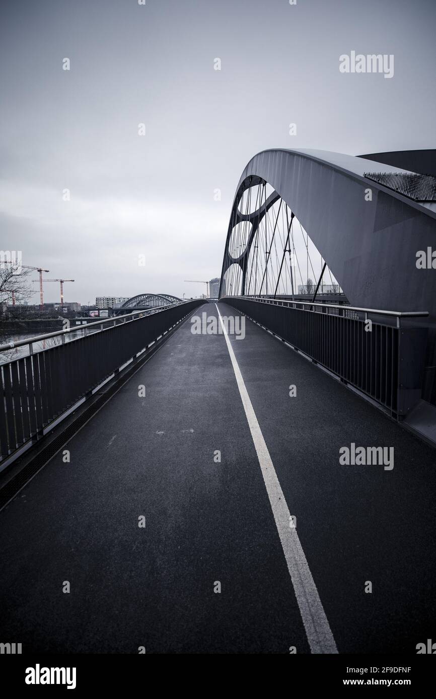 A scenic view of an empty road with steel arch bridge under a gloomy ...