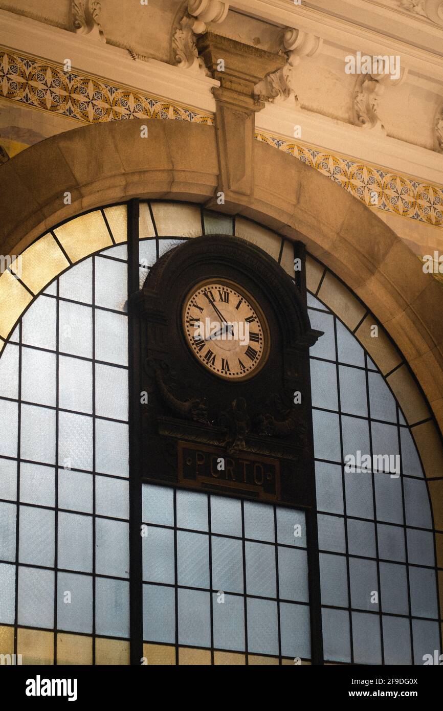 A vertical shot of a big clock in Sao Bento Train Station in Porto ...