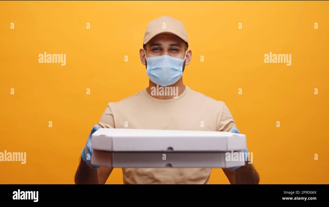 Delivery man smiling while holding pizza boxes. Ordering food during ...