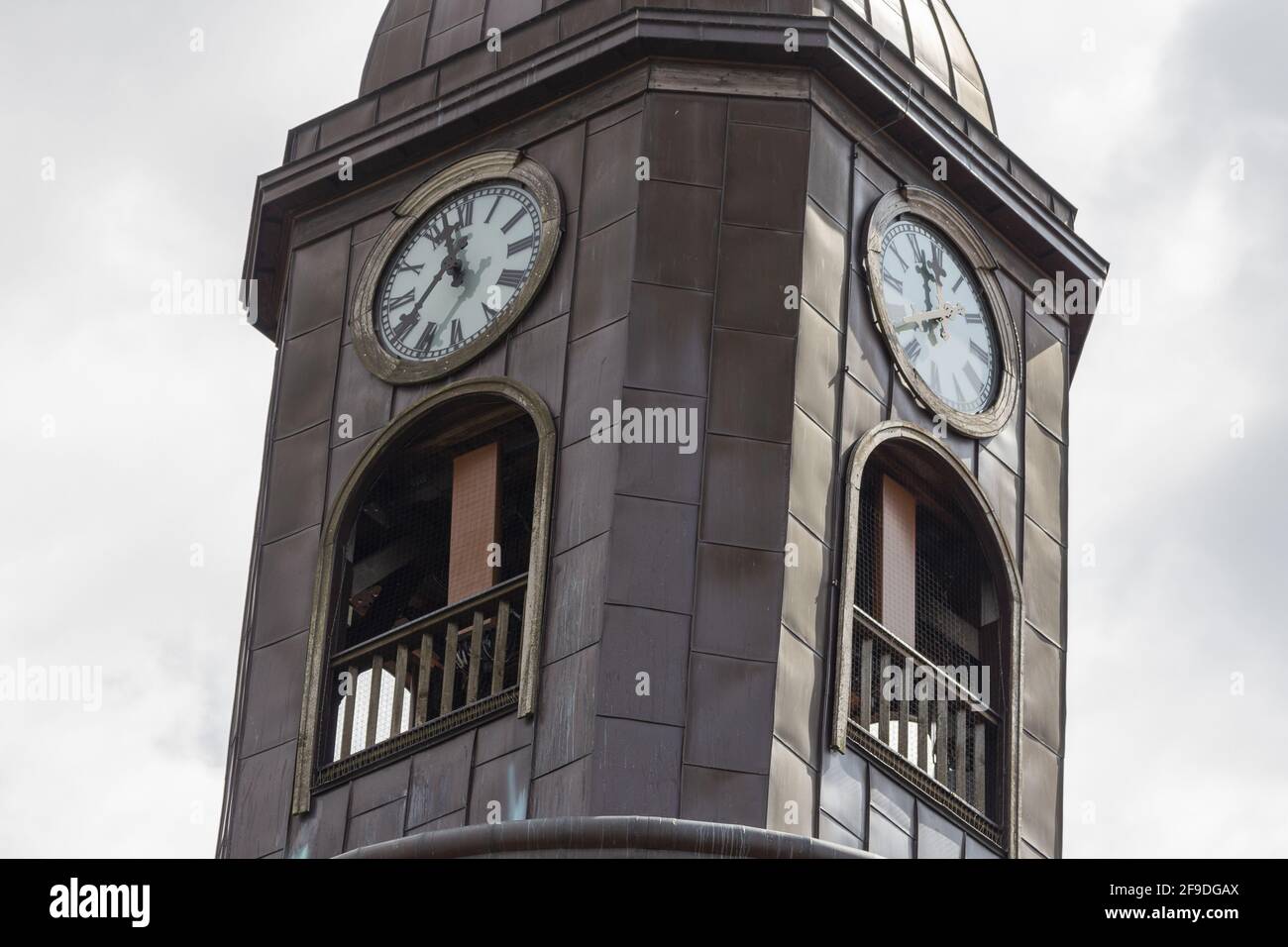 A low angle view of the turret clock on the grey tower on a gloomy day ...