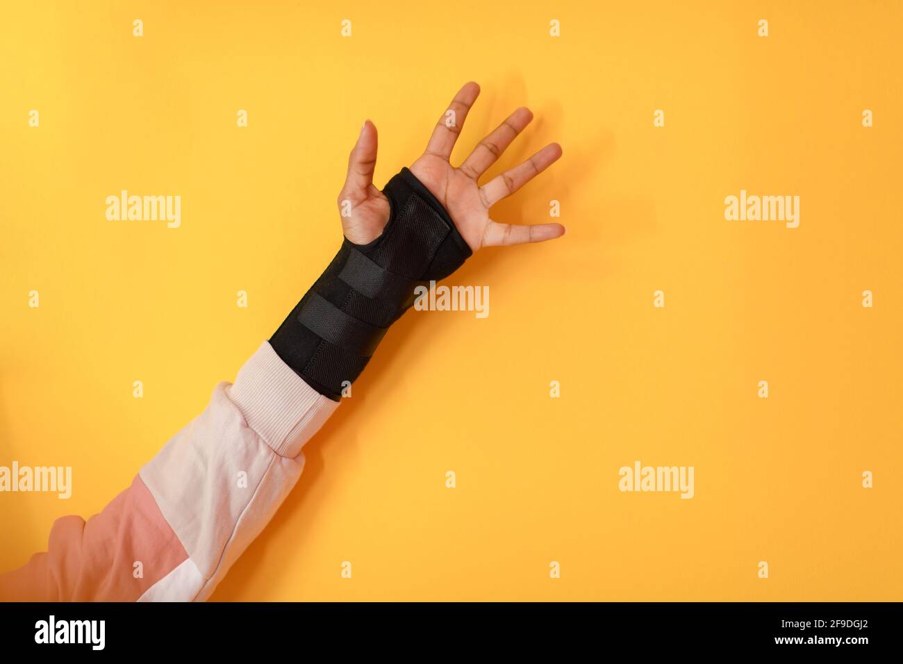 hand injury. a female injured hand on a yellow background Stock Photo ...