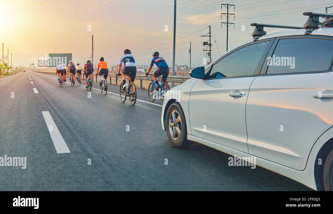 Group of professional cyclists training on highway with safety escort ...