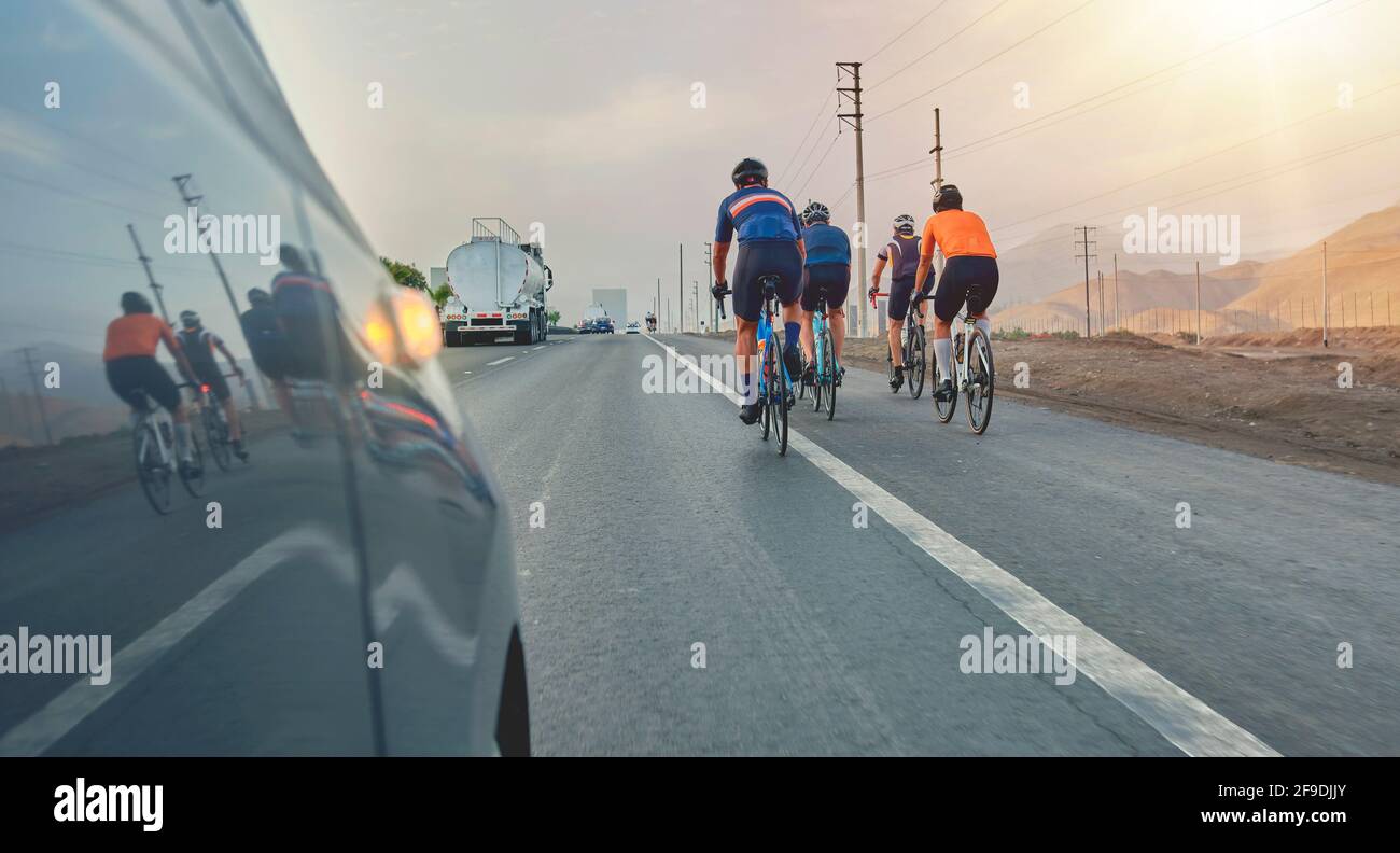Group of professional cyclists training on highway with safety escort ...