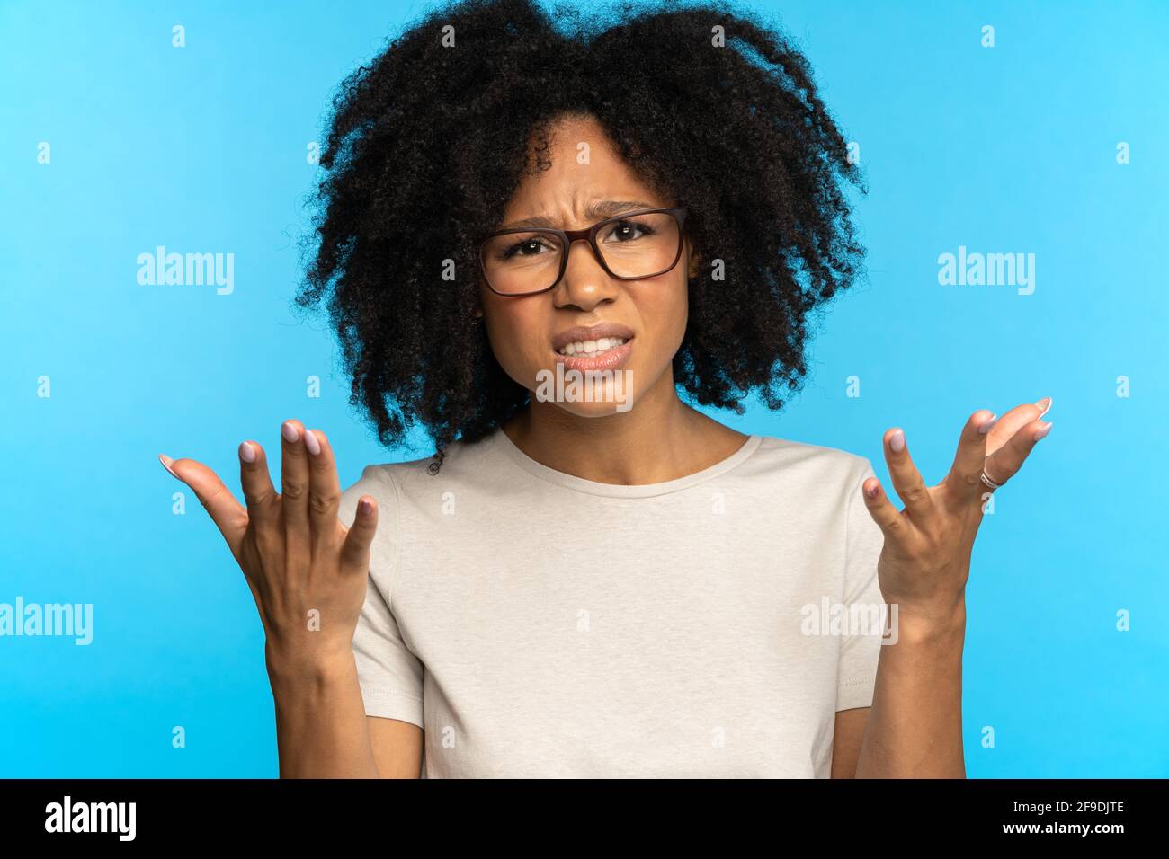 Portrait of mixed race shocked female with frowning open mouth, angry ...
