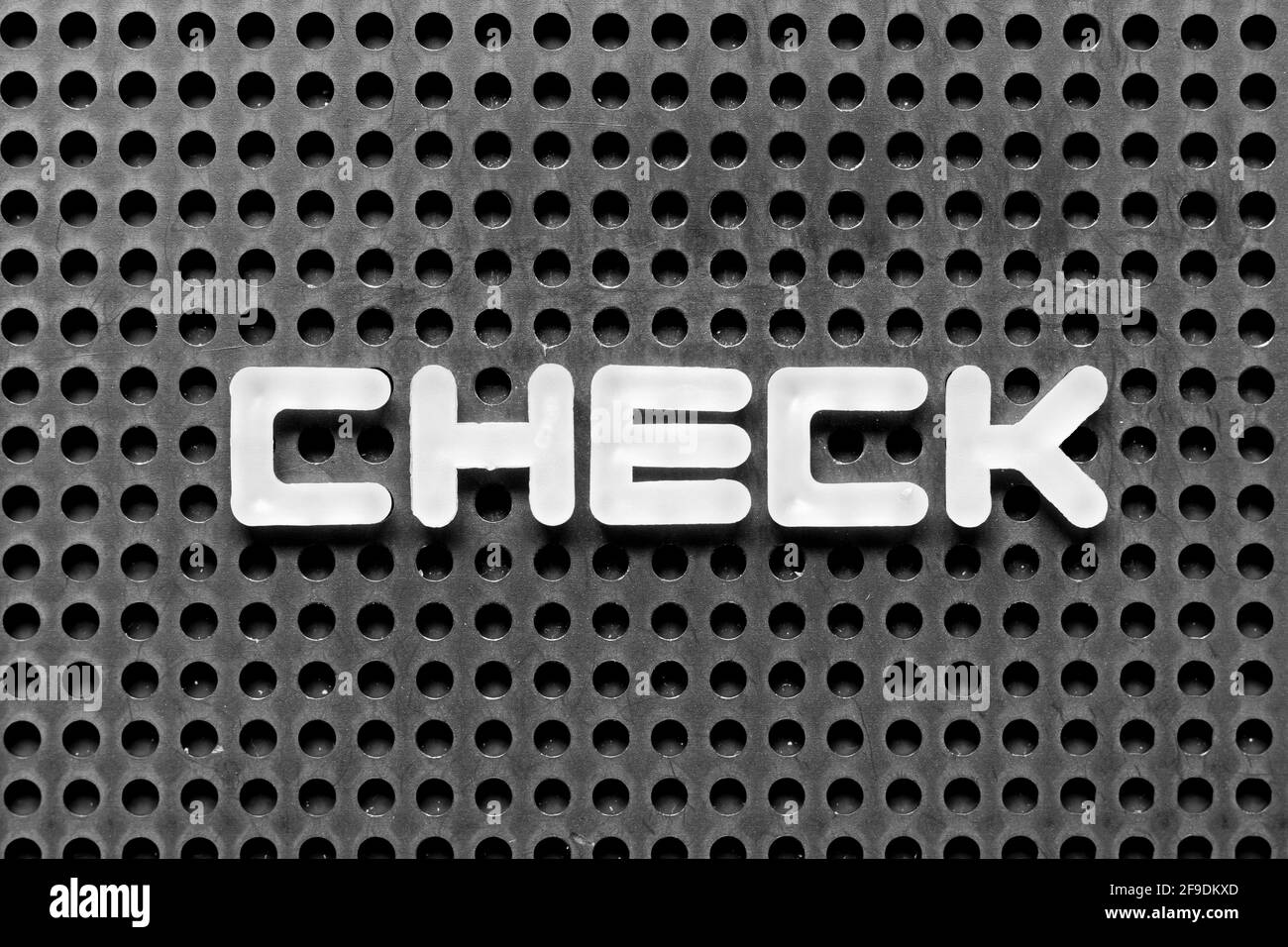 White alphabet letter in word check on black pegboard background Stock ...