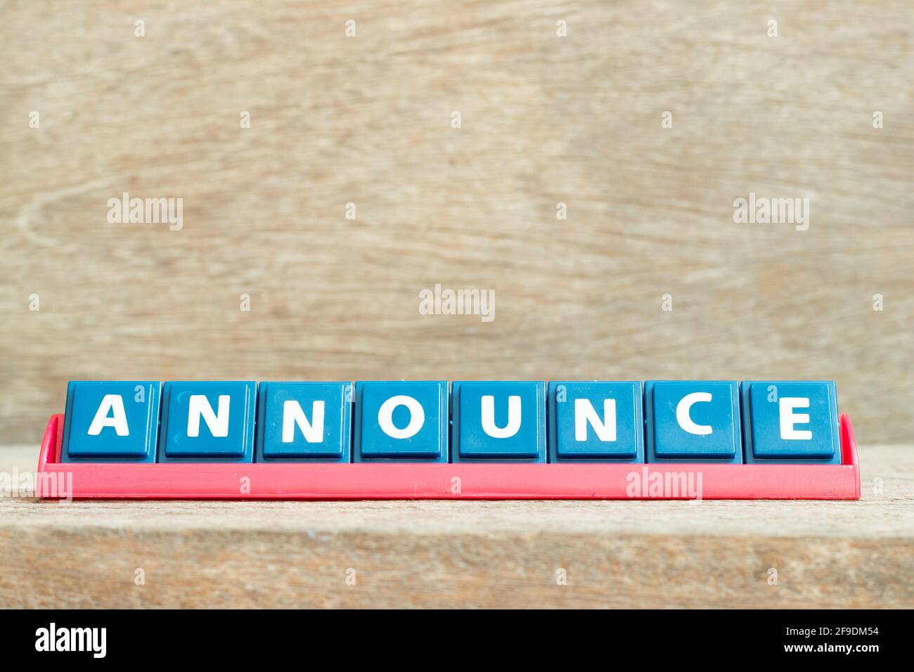 Tile alphabet letter with word announce in red color rack on wood ...