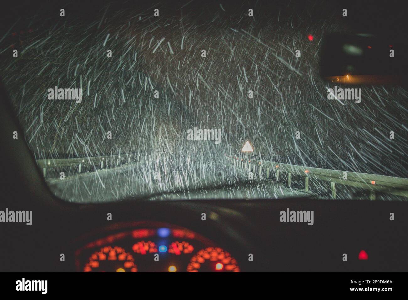 A dangerous night drive through a snowy highway with sharp flakes ...