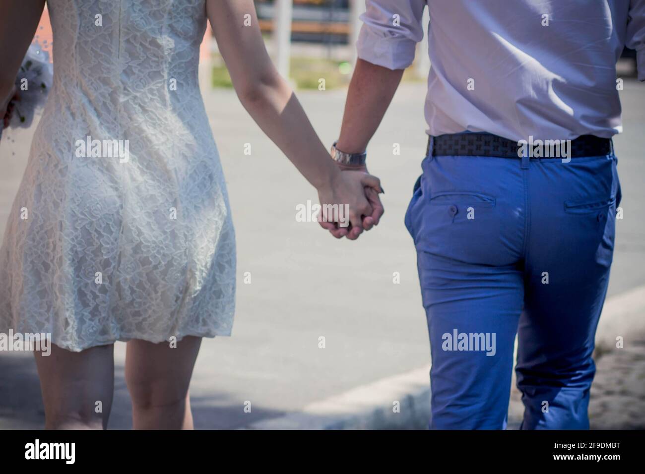 A back view of a young couple holding hands Stock Photo - Alamy