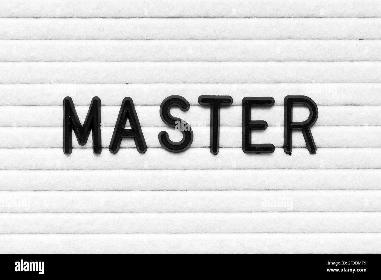 Black alphabet letter in word master on white felt board background ...