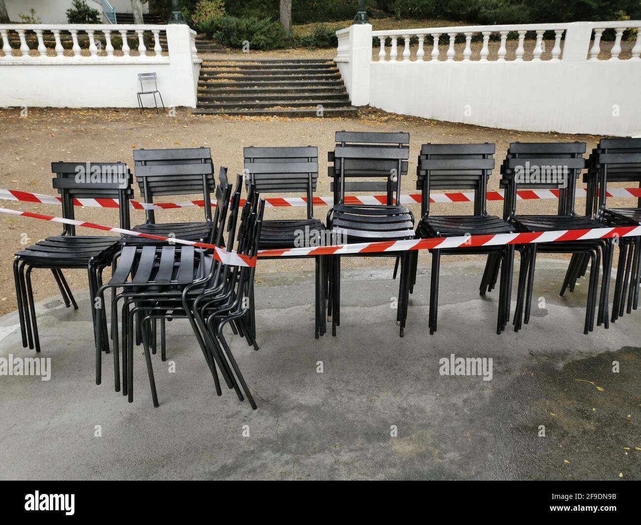 A row of piled chairs under the rain attached by a warning tape Stock ...