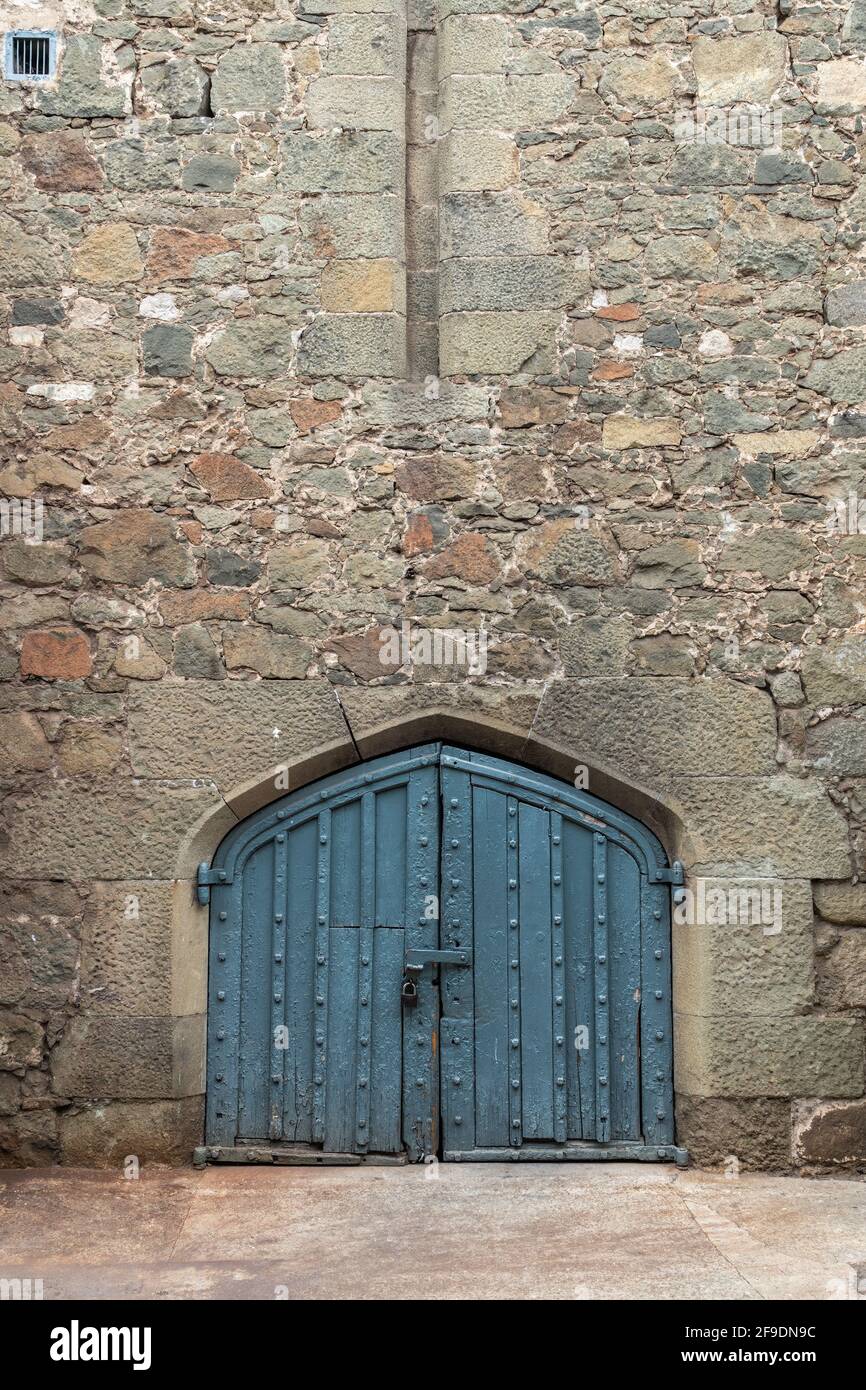 Ancient stone wall with a gate in the old castle. Wooden gate of a ...