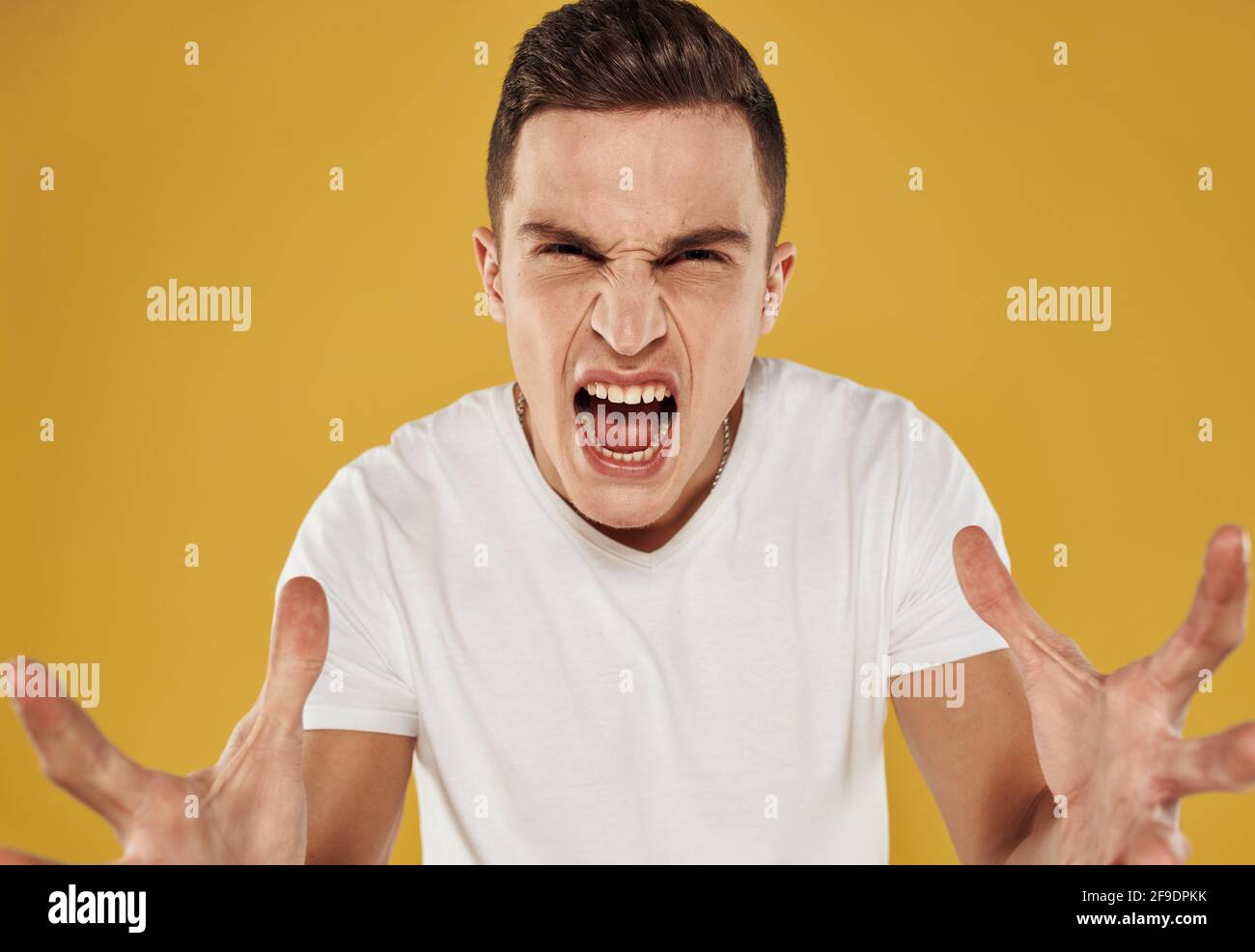 Angry man on a yellow background cry of emotion and stress Stock Photo ...