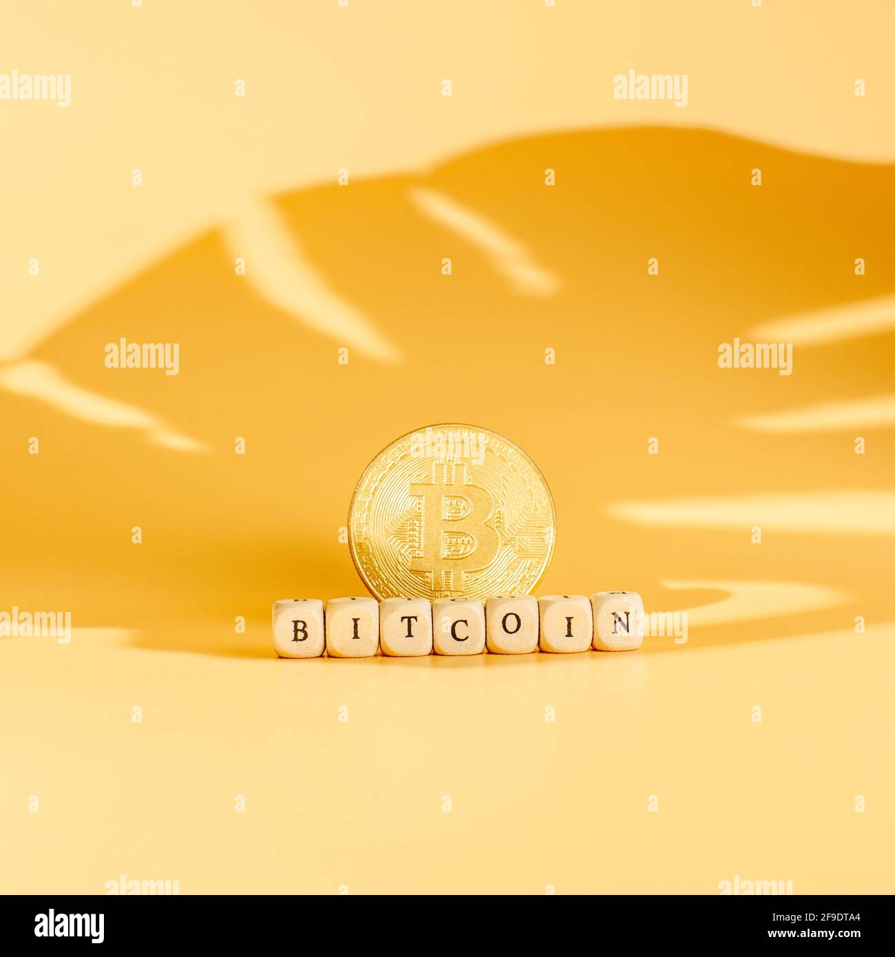 Bitcoin in a minimalist concept shadow on a yellow background with the ...