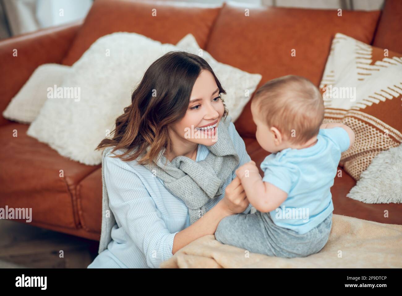 Mom attracting childs attention and playing with him Stock Photo - Alamy