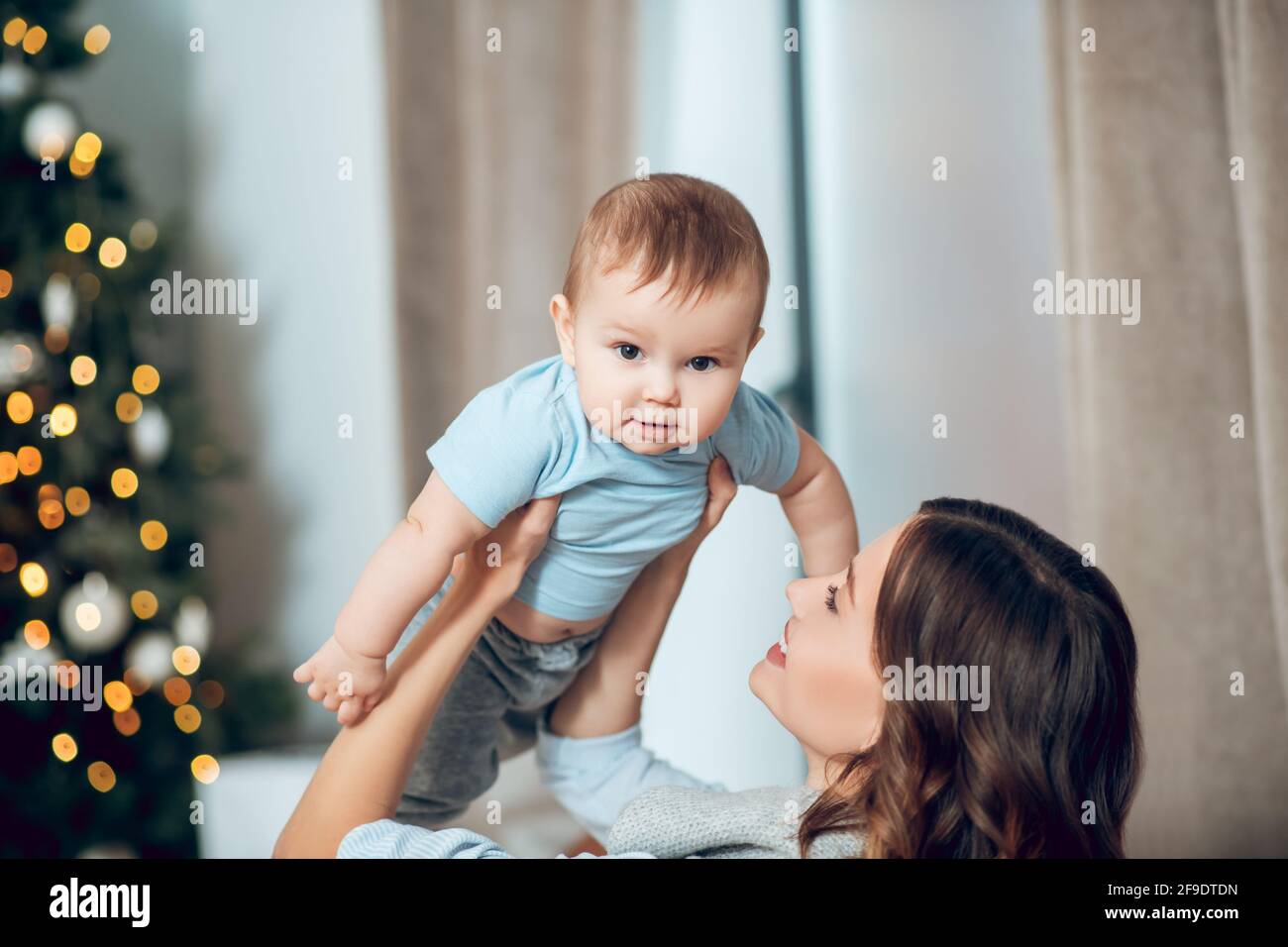 Contented woman raising up with hands small child Stock Photo - Alamy