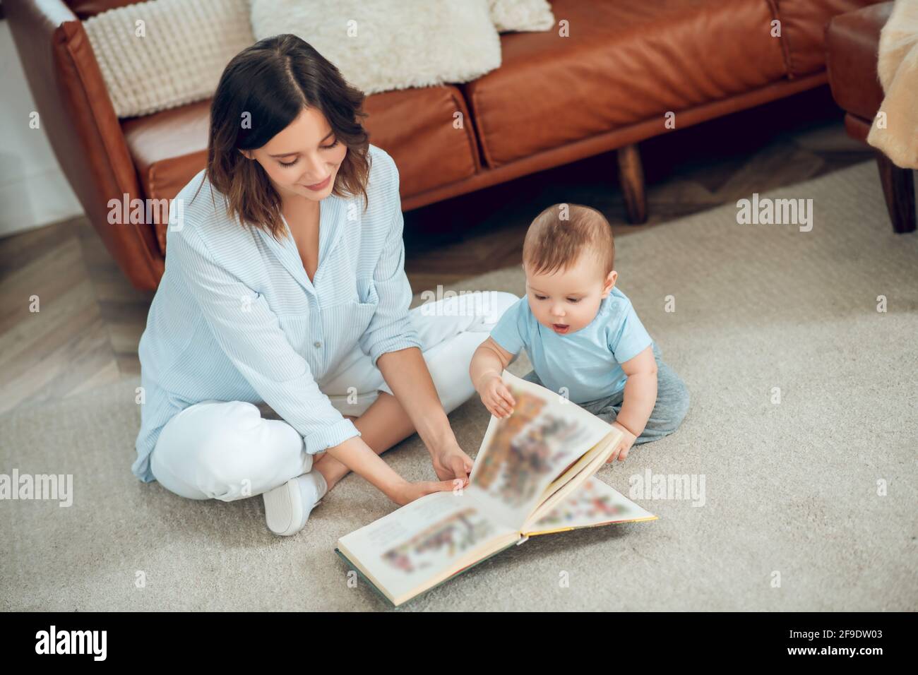 Interested mom and child looking at book Stock Photo - Alamy