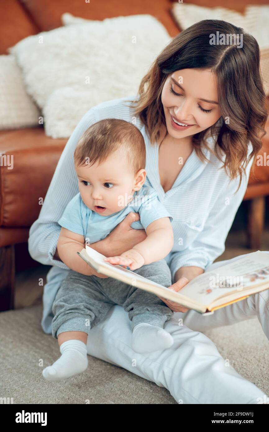 Mom reading book and little distracted child Stock Photo - Alamy