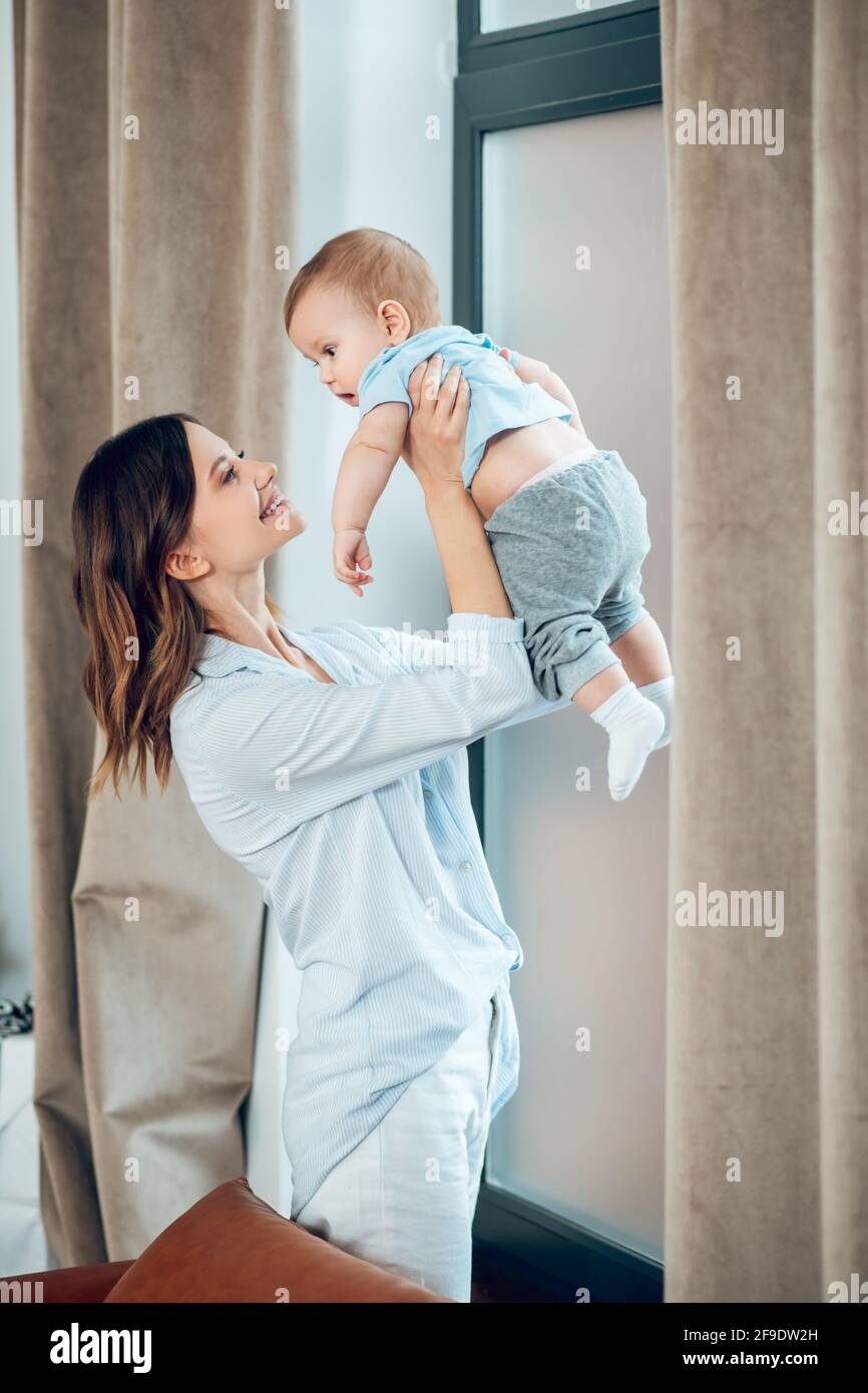 Happy woman raising up small child Stock Photo - Alamy