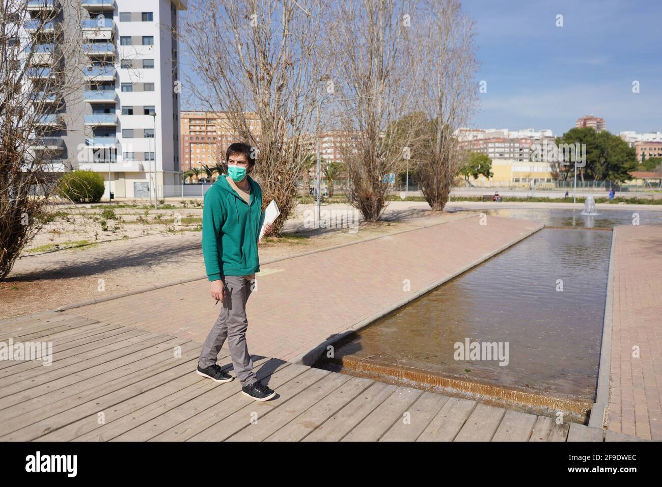A closeup shot of a Spanish man wearing a face mask and taking notes ...