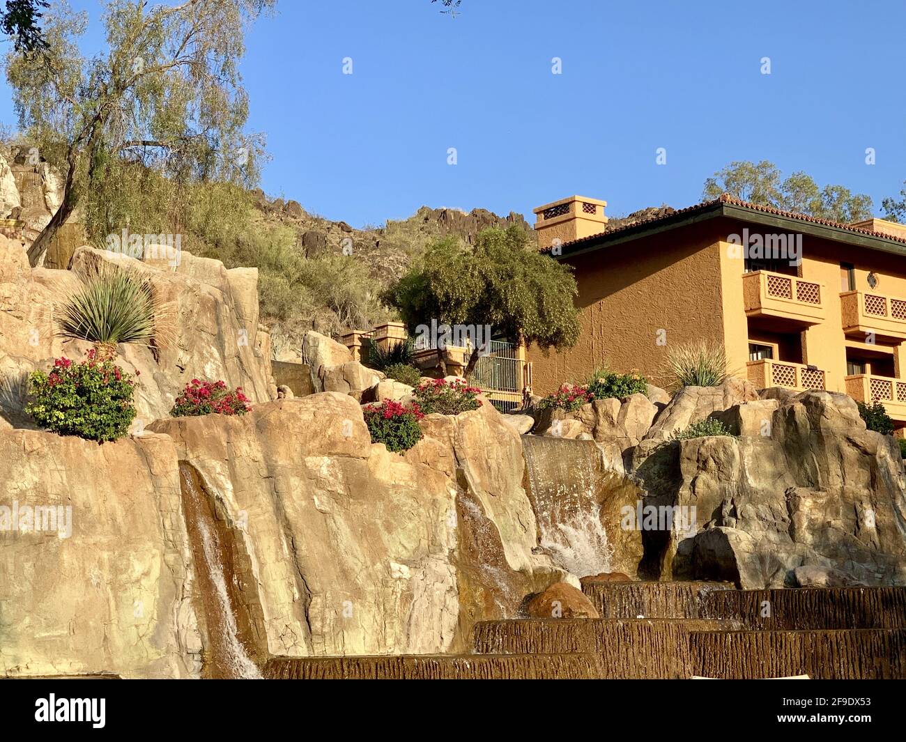 A view of a luxury resort with a waterfall feature in the foreground ...
