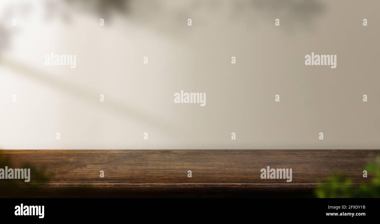 dark brown wood table background with leaf shadow on wall and plant at ...