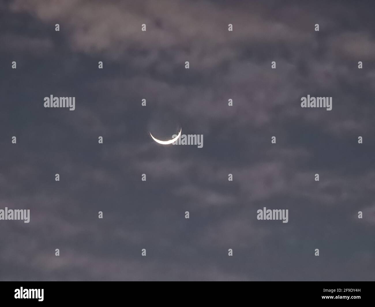 A mesmerizing view of a crescent moon in a cloudy dark sky Stock Photo ...